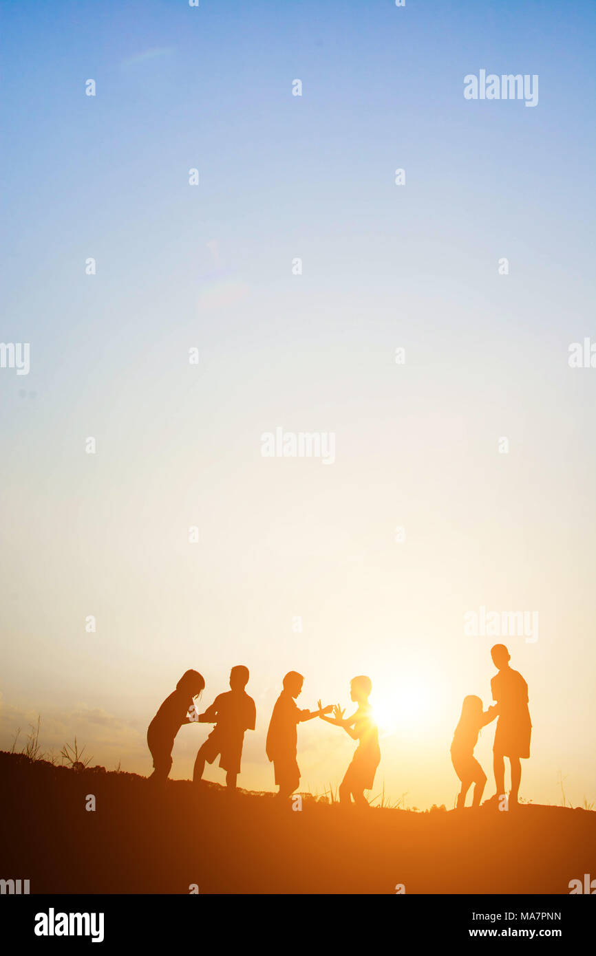 Children playing on summer sunset happy time Stock Photo - Alamy