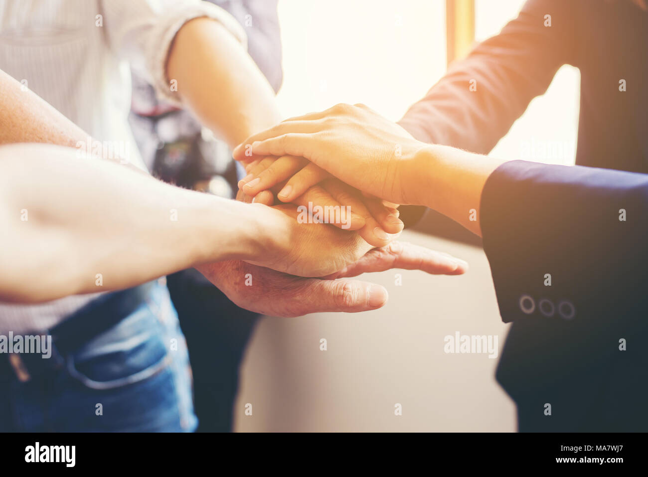 Concept of teamwork: Close-Up of hands business team showing unity with putting their hands ...