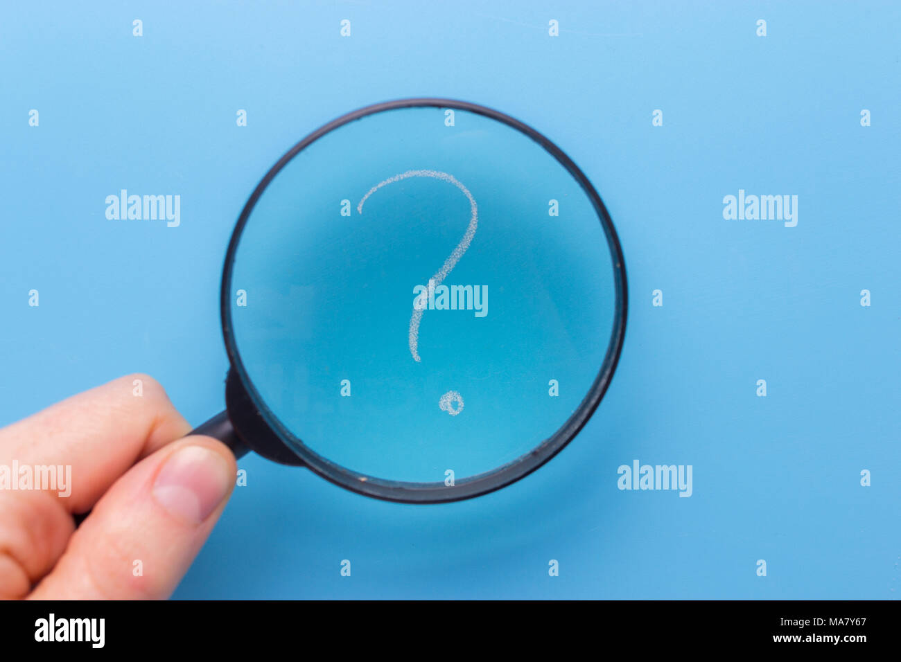 question mark under a magnifying glass with blue background Stock Photo ...