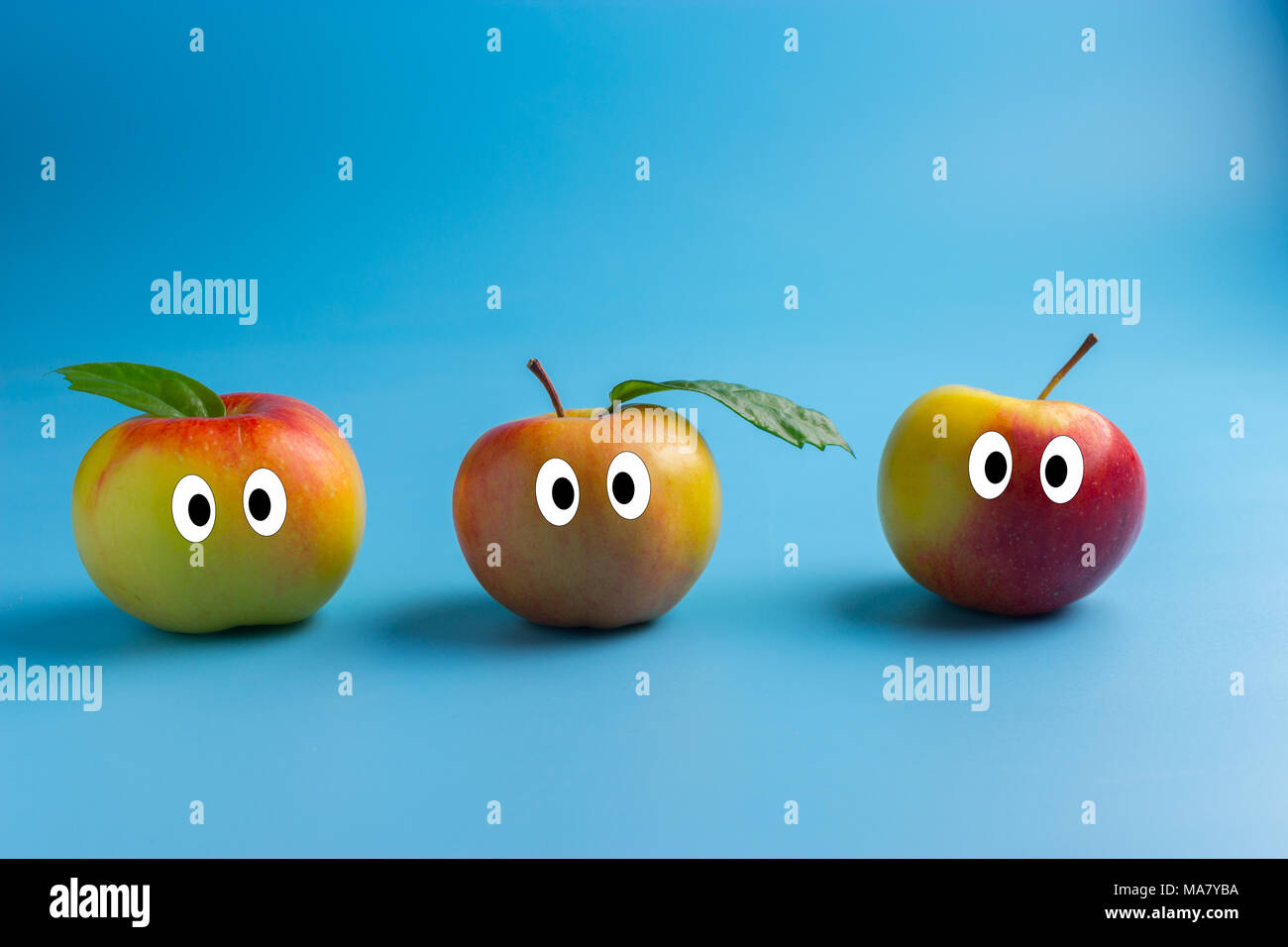 Apple Smiley. apple with eyes on blue background Stock Photo - Alamy
