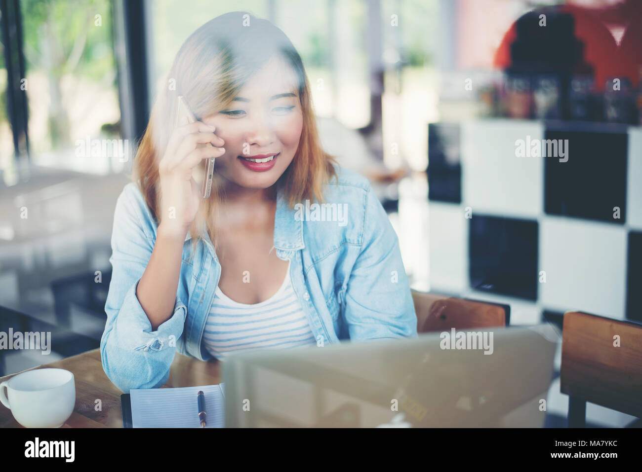 Young hipster woman talking phone and working at coffee shop Stock ...