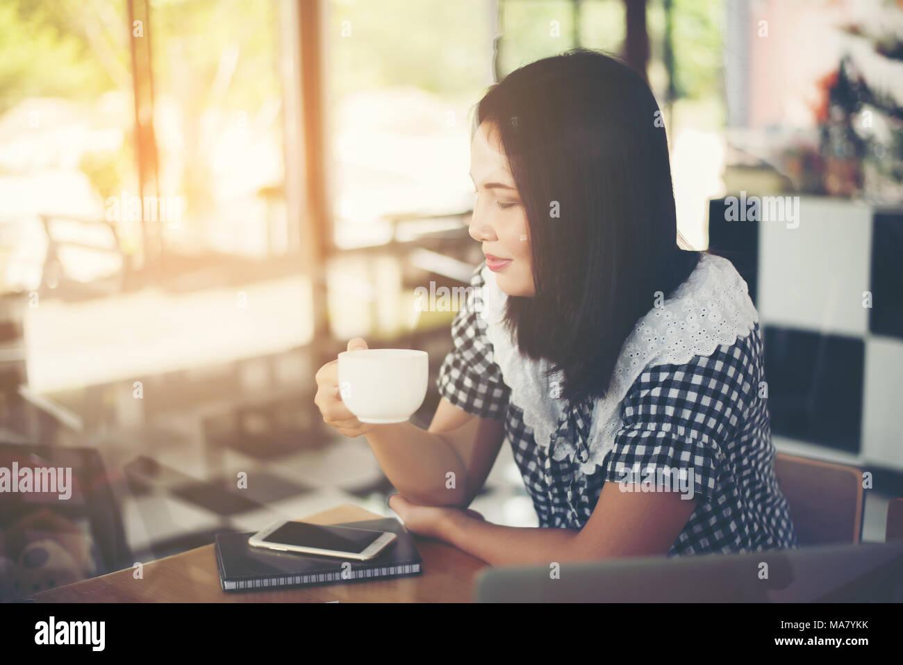 Beautiful woman sitting and drinking coffee at cafe Stock Photo - Alamy