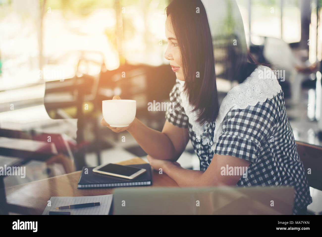 Beautiful woman sitting and drinking coffee at cafe Stock Photo - Alamy