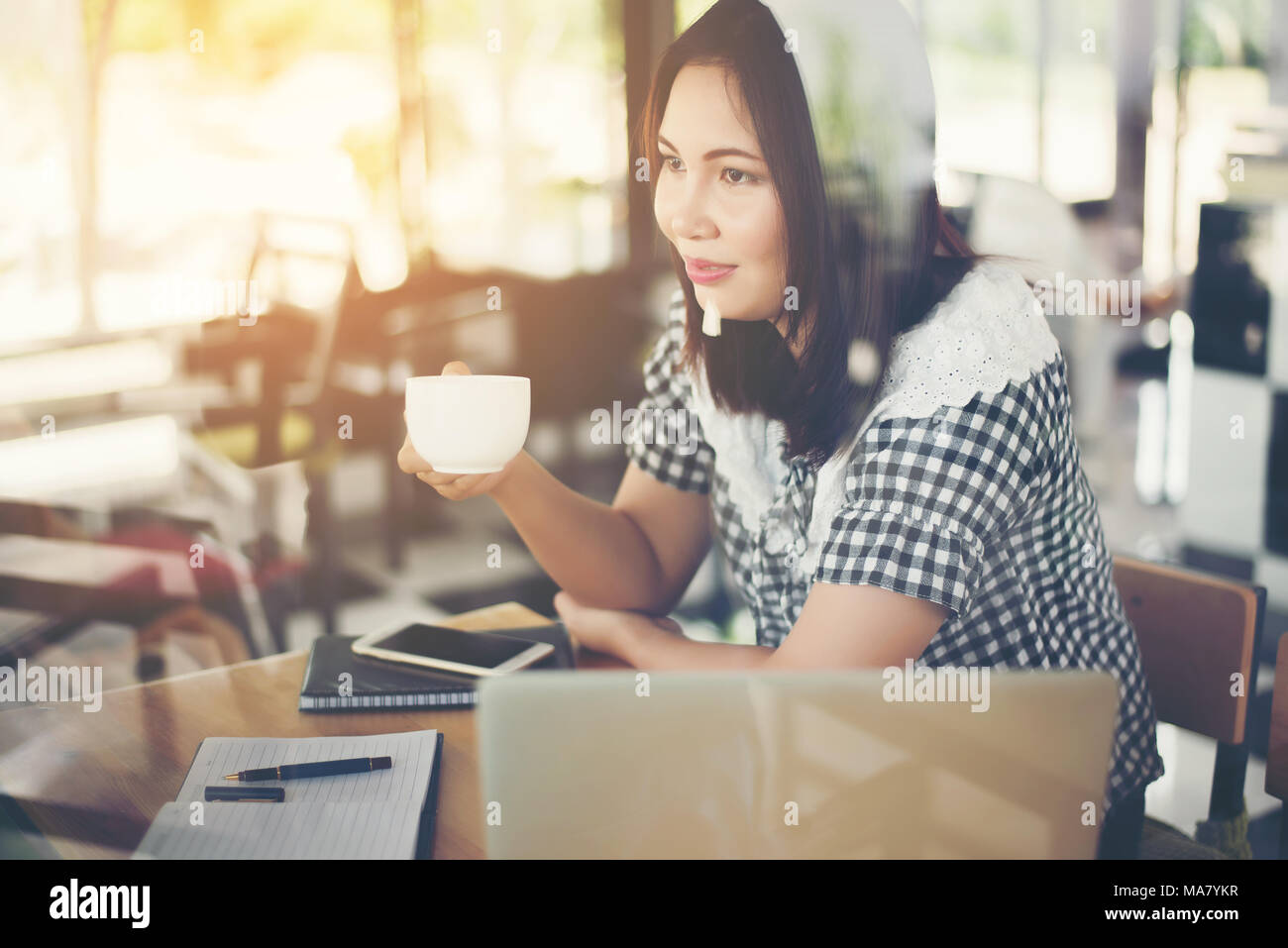 Beautiful woman sitting and drinking coffee at cafe Stock Photo - Alamy