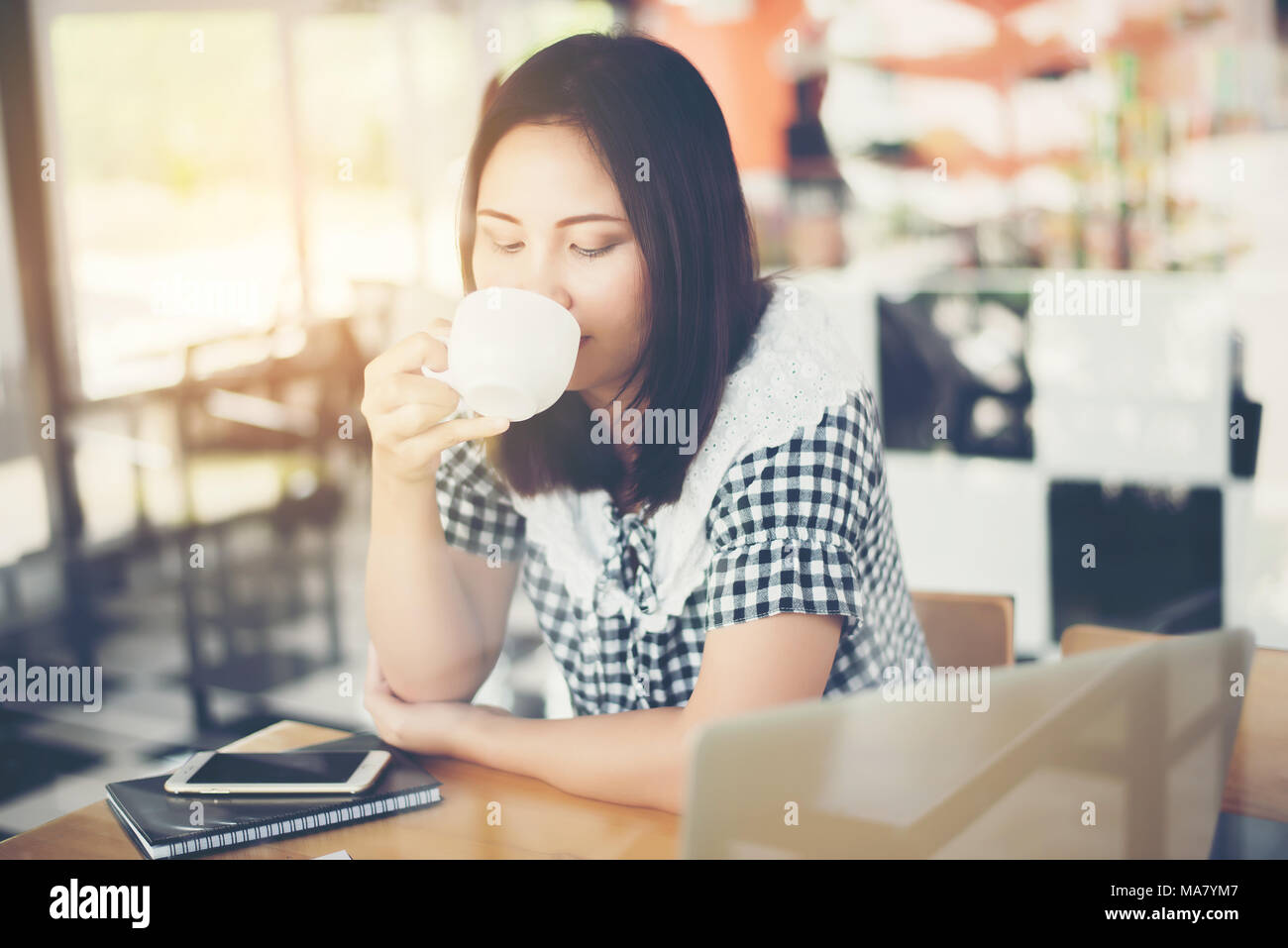 Beautiful woman sitting and drinking coffee at cafe Stock Photo - Alamy