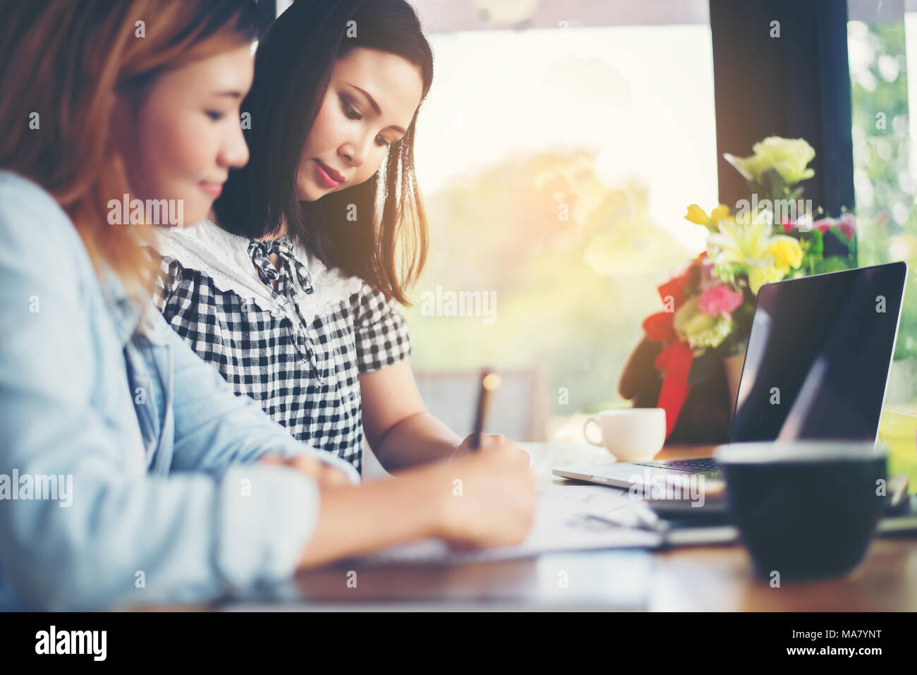 Two friends enjoying working together at coffee shop Stock Photo - Alamy