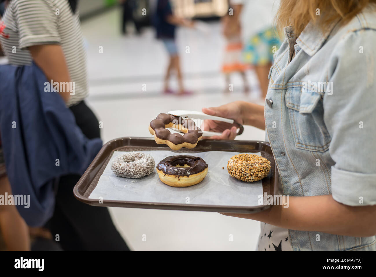 Woman grabbing donut hi-res stock photography and images - Alamy