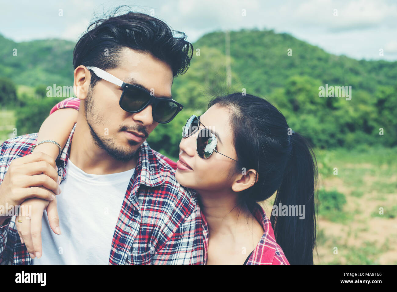 Close up portrait of happy hipster couple in love wearing glasses hugs ...