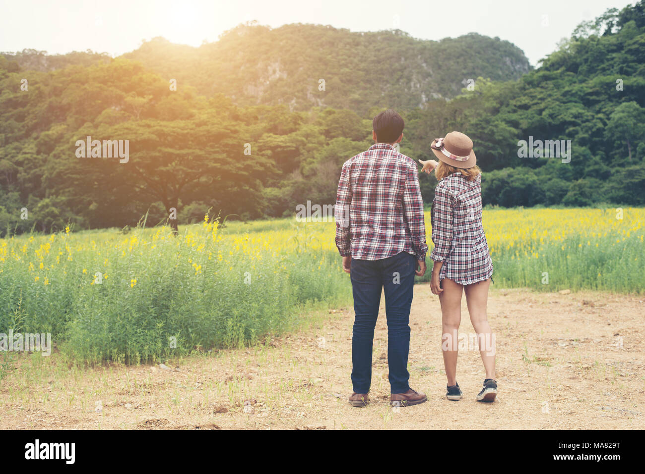Young hipster couple taking a walk on beautiful flower field Stock ...