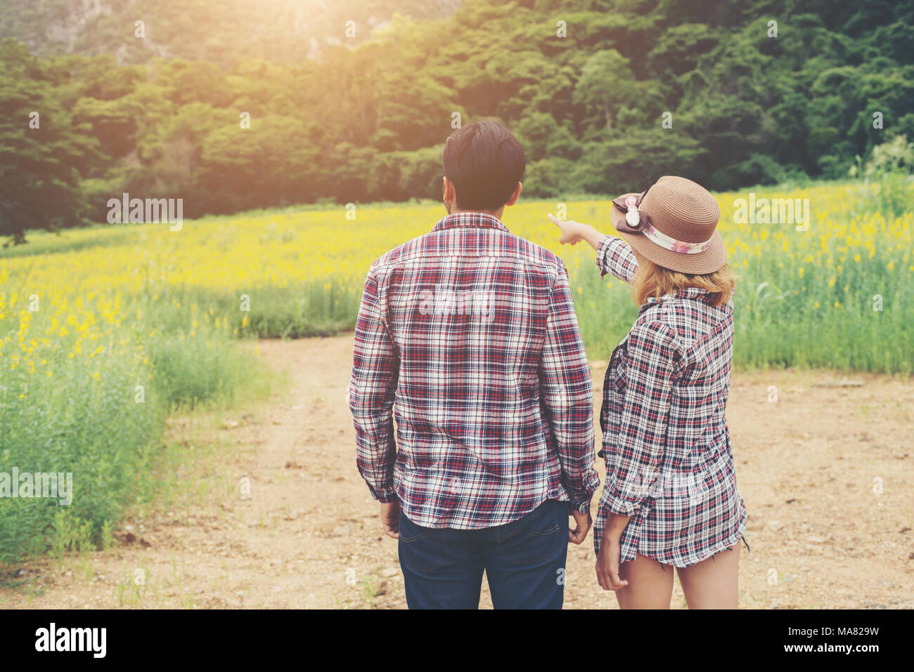 Young hipster couple taking a walk on beautiful flower field Stock ...