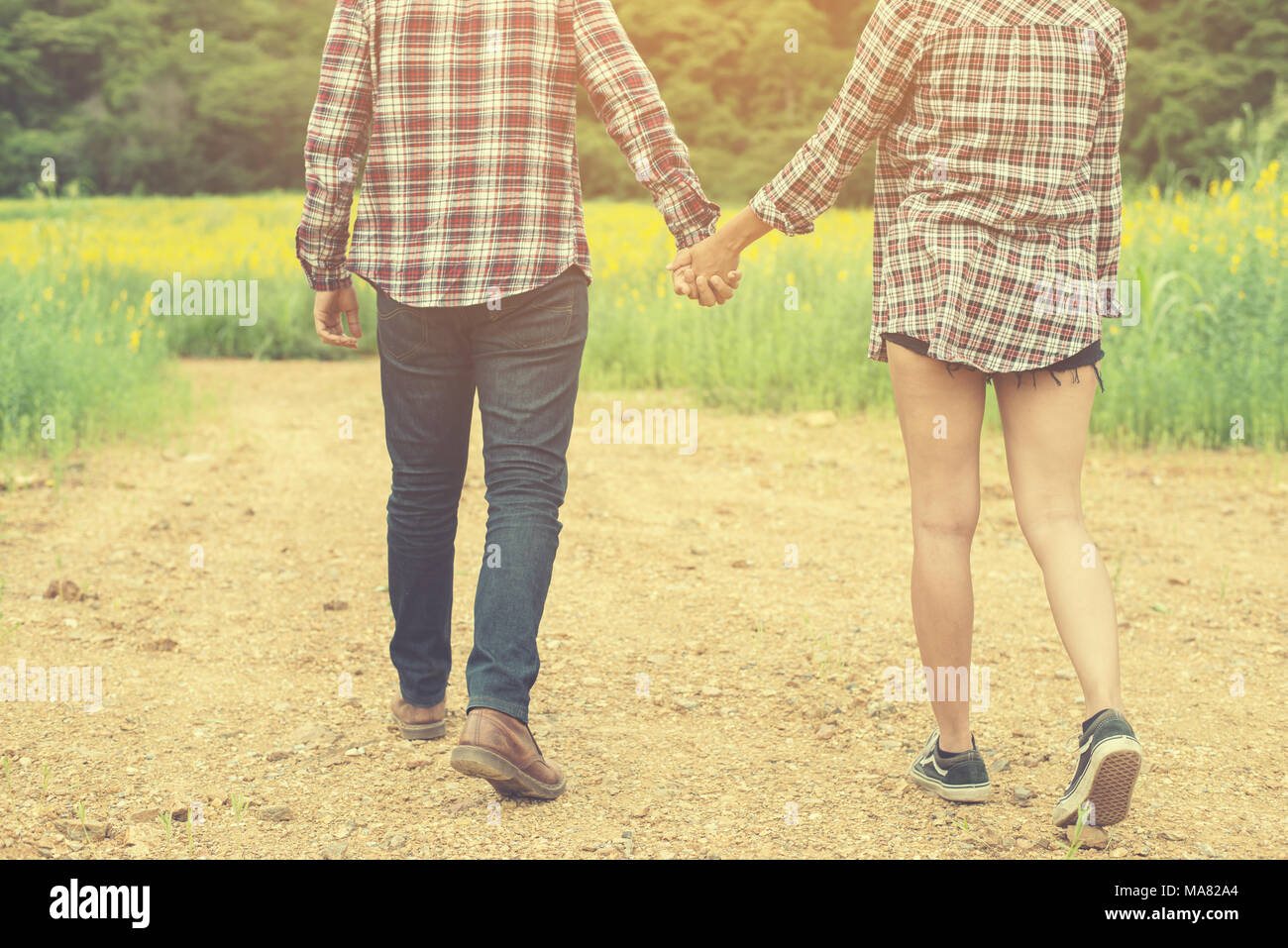 Young hipster couple taking a walk on beautiful flower field Stock ...