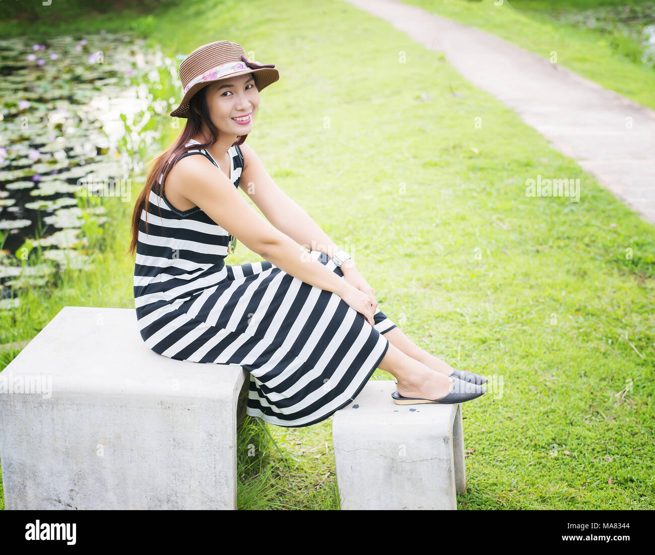 young beautiful woman sitting on bench in green park Stock Photo - Alamy