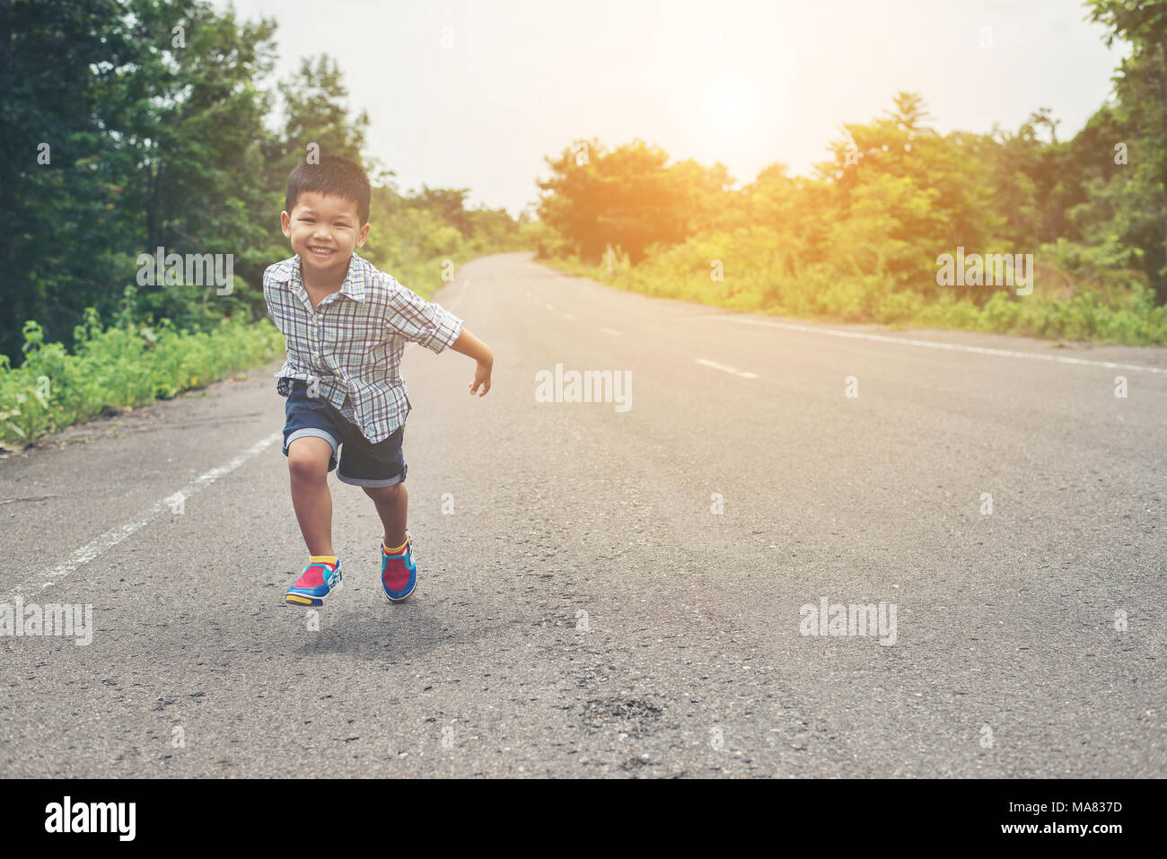 Happy little boy in motion, smiley running on the street Stock Photo ...