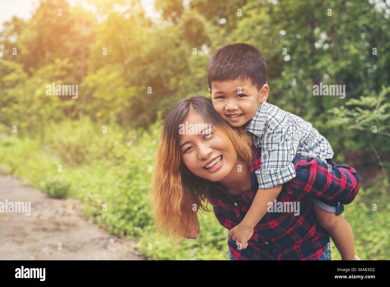 Happy little cute asian boy enjoying a piggyback ride on his mother's back Stock Photo - Alamy
