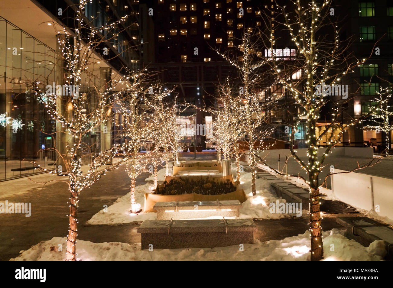 Brightly lit Christmas decorated alley in front of a skyscraper in ...
