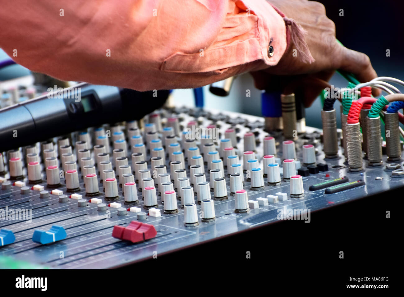 Sound engineer adjusting audio mixing console Stock Photo - Alamy