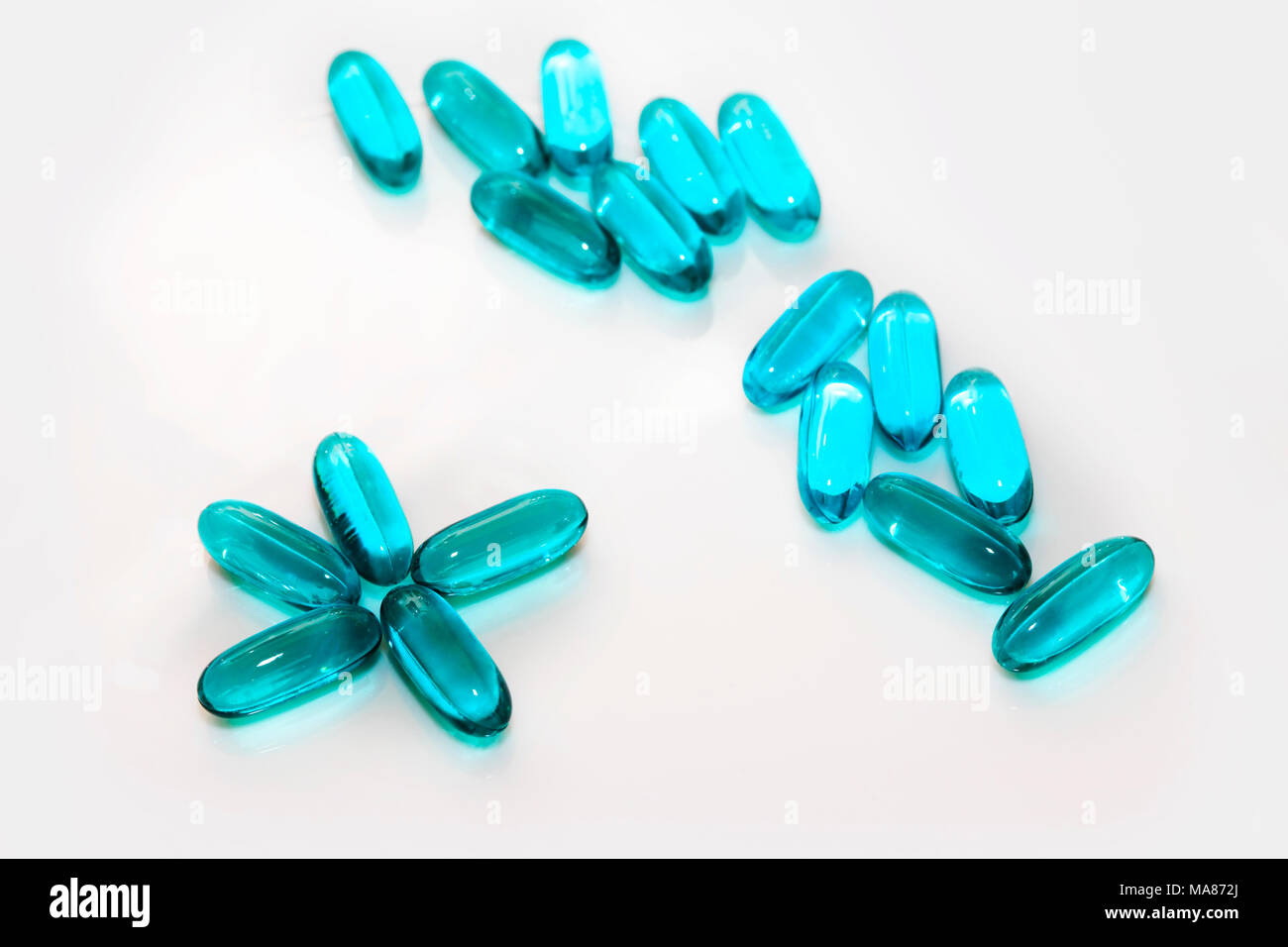 Blue capsules on white background close up Stock Photo - Alamy
