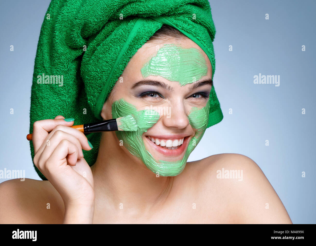 Young beautiful girl receiving cosmetic facial mask. Portrait of ...