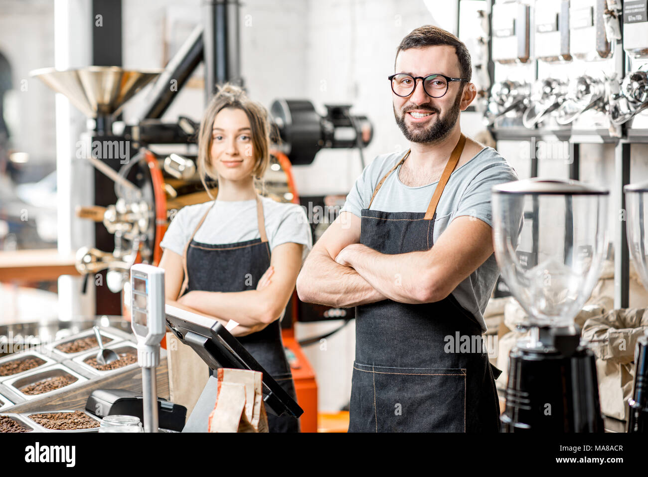 Portrait of a two sales persons standing in the coffee store with ...