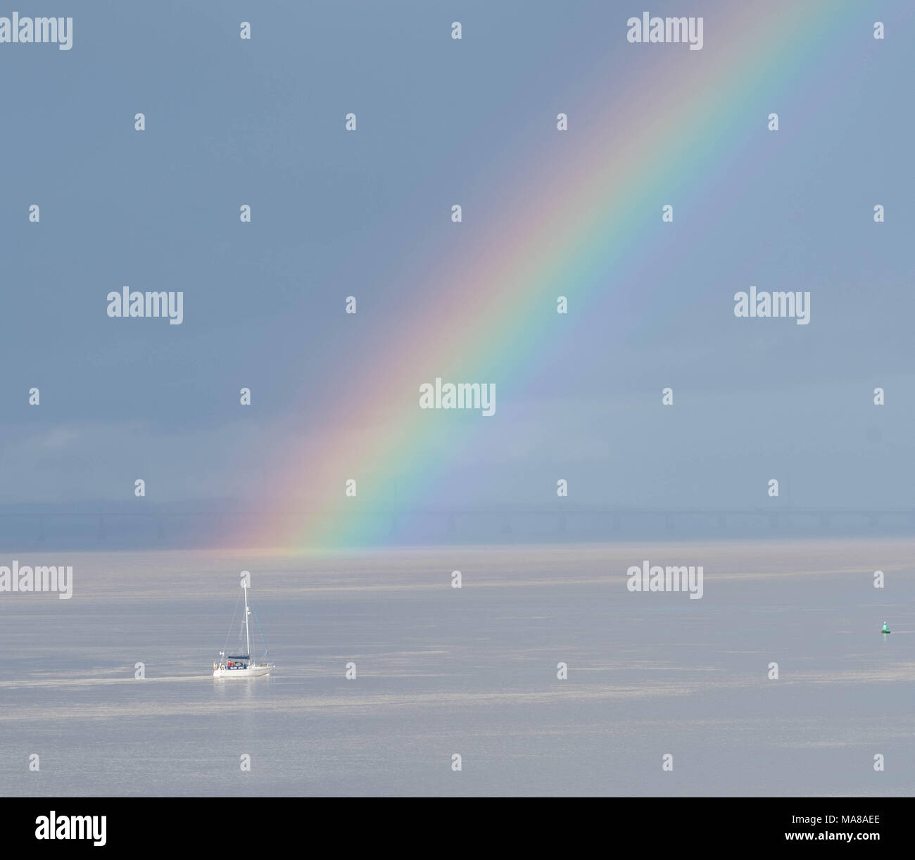 A yacht passes under a rainbow over the Severn estuary Stock Photo - Alamy