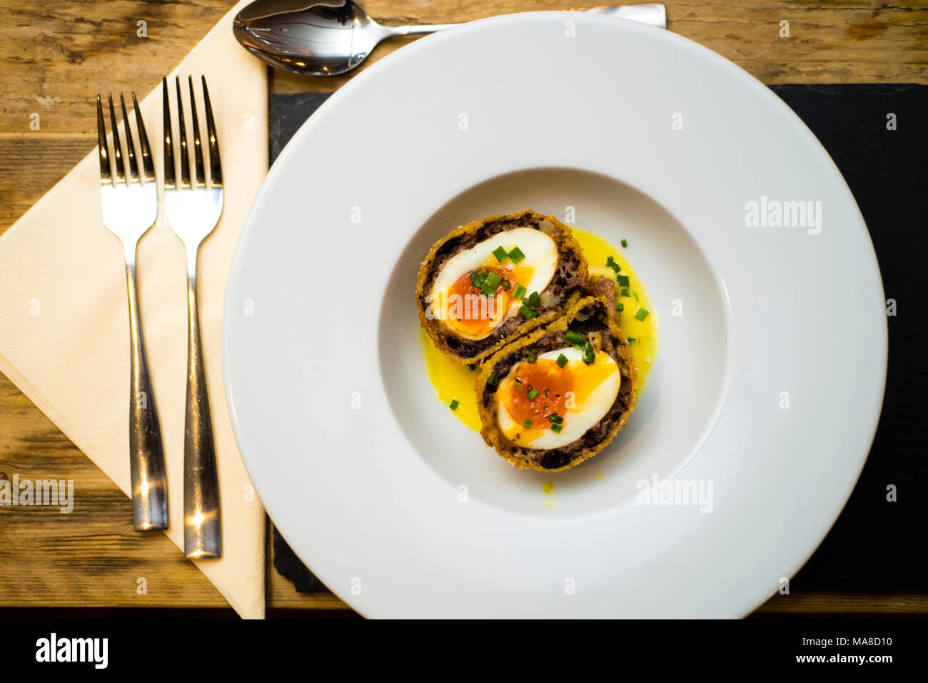 Artisan food: hand made scotch egg on a white plate in a restaurant UK ...