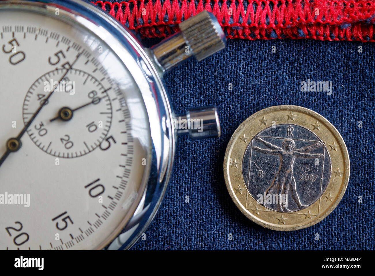 Euro coin with a denomination of 1 euro (back side) and stopwatch on ...
