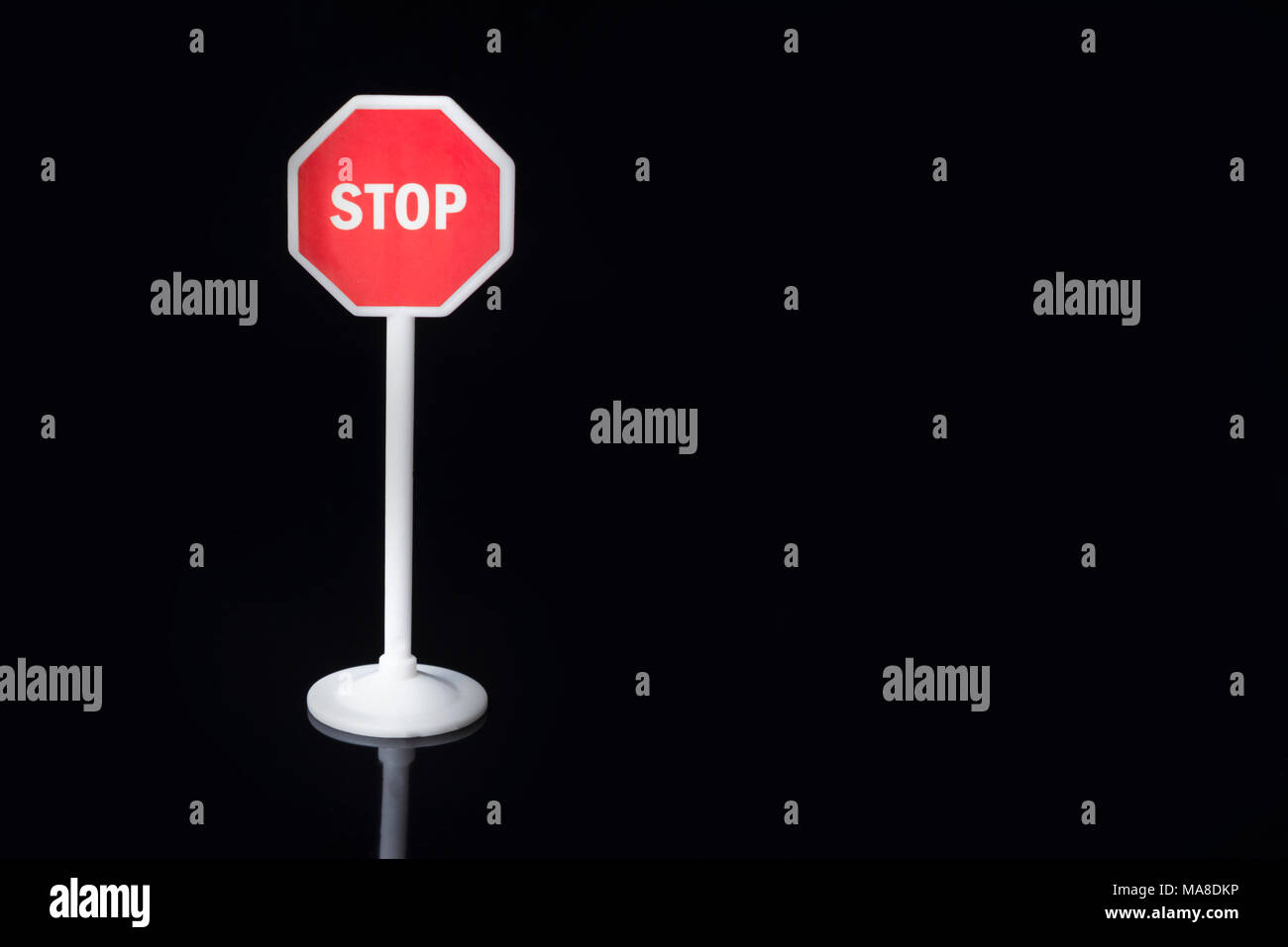 Octagonal red stop sign on a black background Stock Photo - Alamy