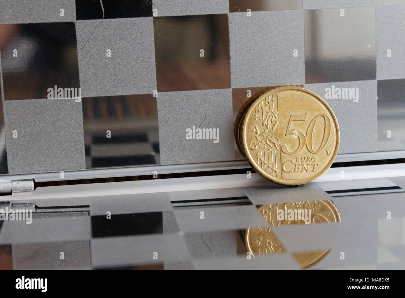 Euro coins in mirror reflect lies in chequered wallet, background ...