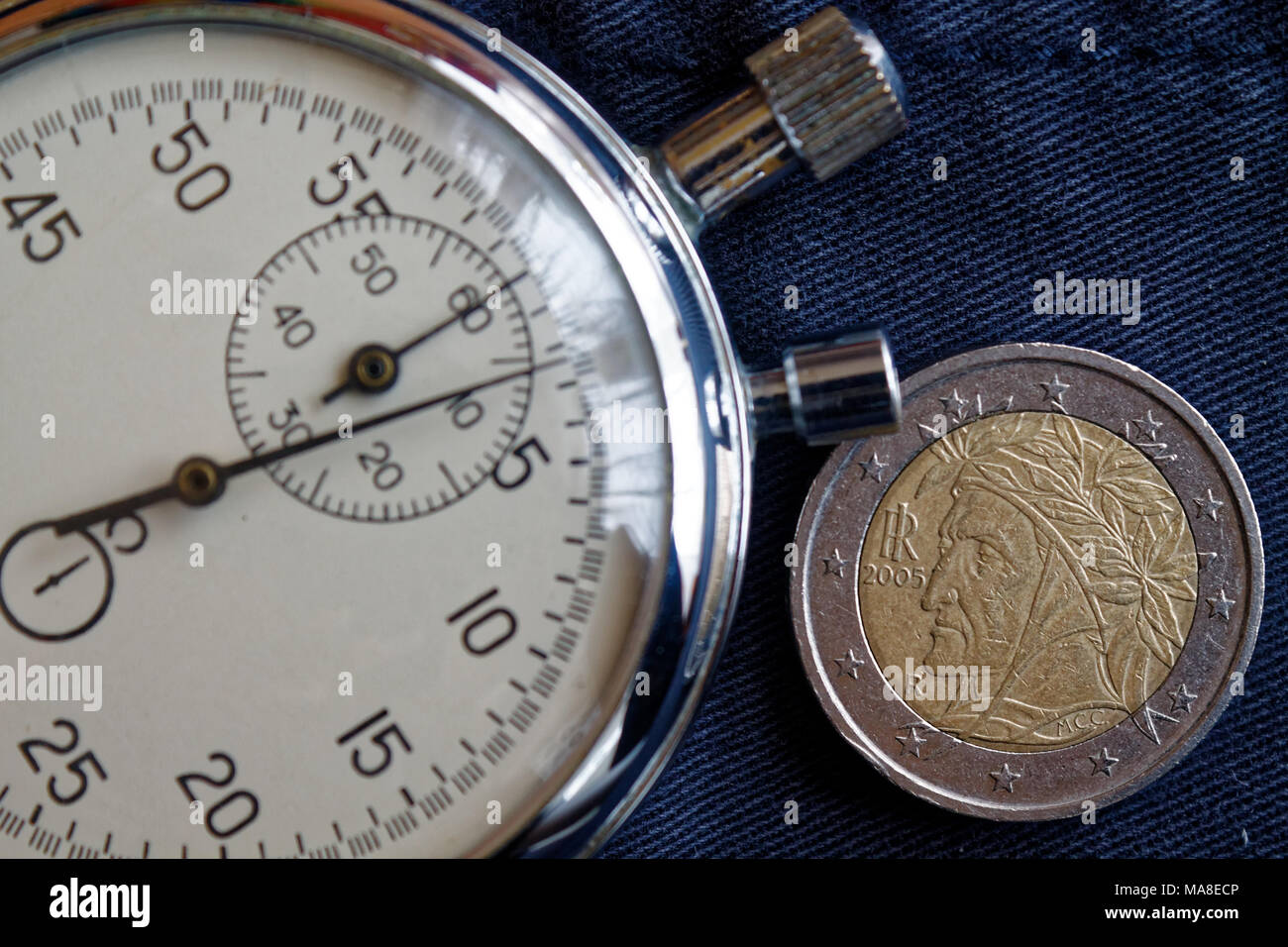 Euro coin with a denomination of 2 euro (back side) and stopwatch on ...
