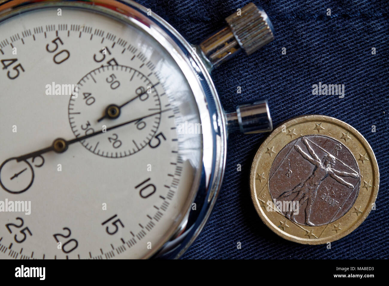 Euro coin with a denomination of 1 euro (back side) and stopwatch on ...