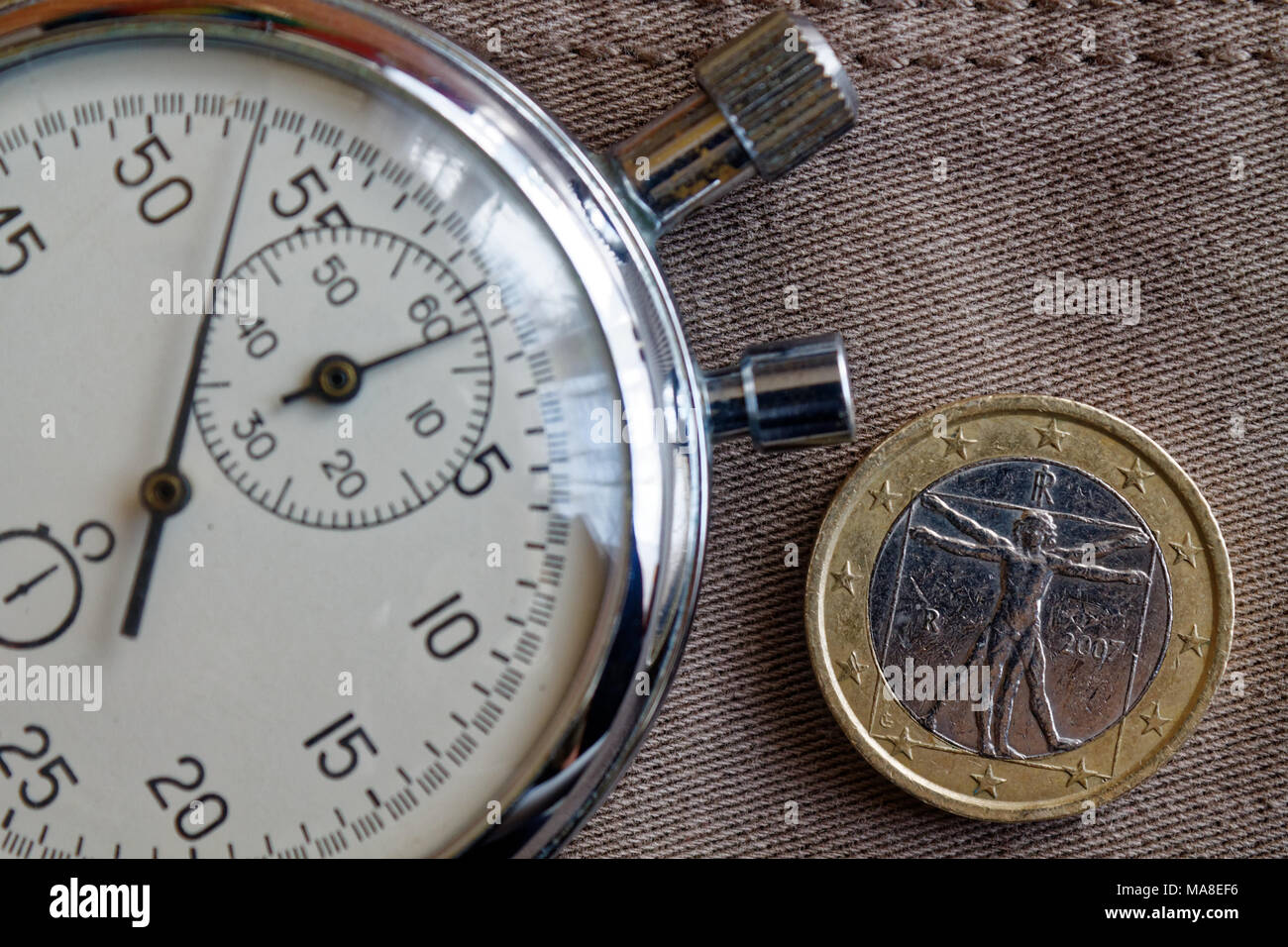 Euro coin with a denomination of 1 euro (back side) and stopwatch on ...