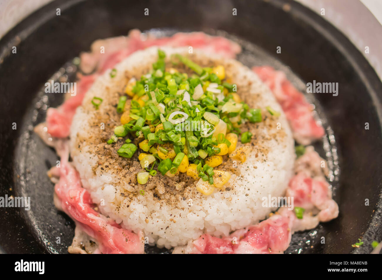 Rice and pork with corn served in hot pan Stock Photo - Alamy