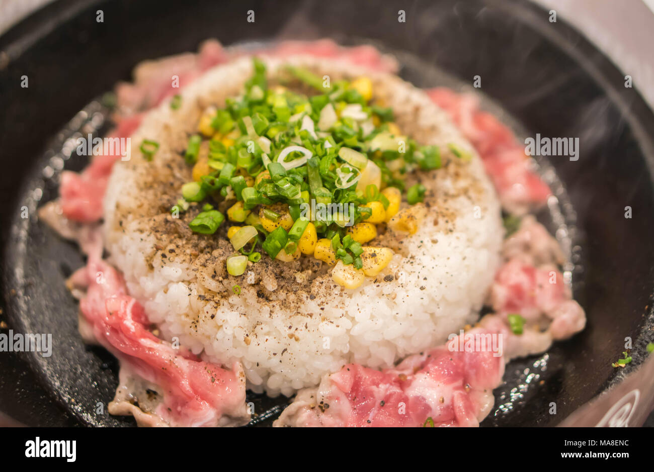 Rice and pork with corn served in hot pan Stock Photo - Alamy