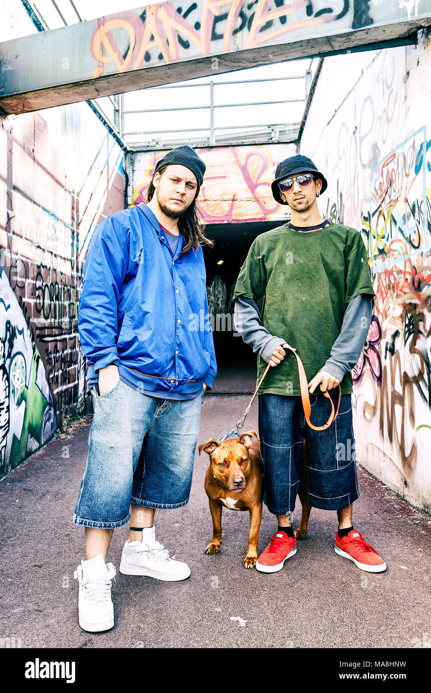 two rap singers with a dog in a subway with graffiti in the background ...