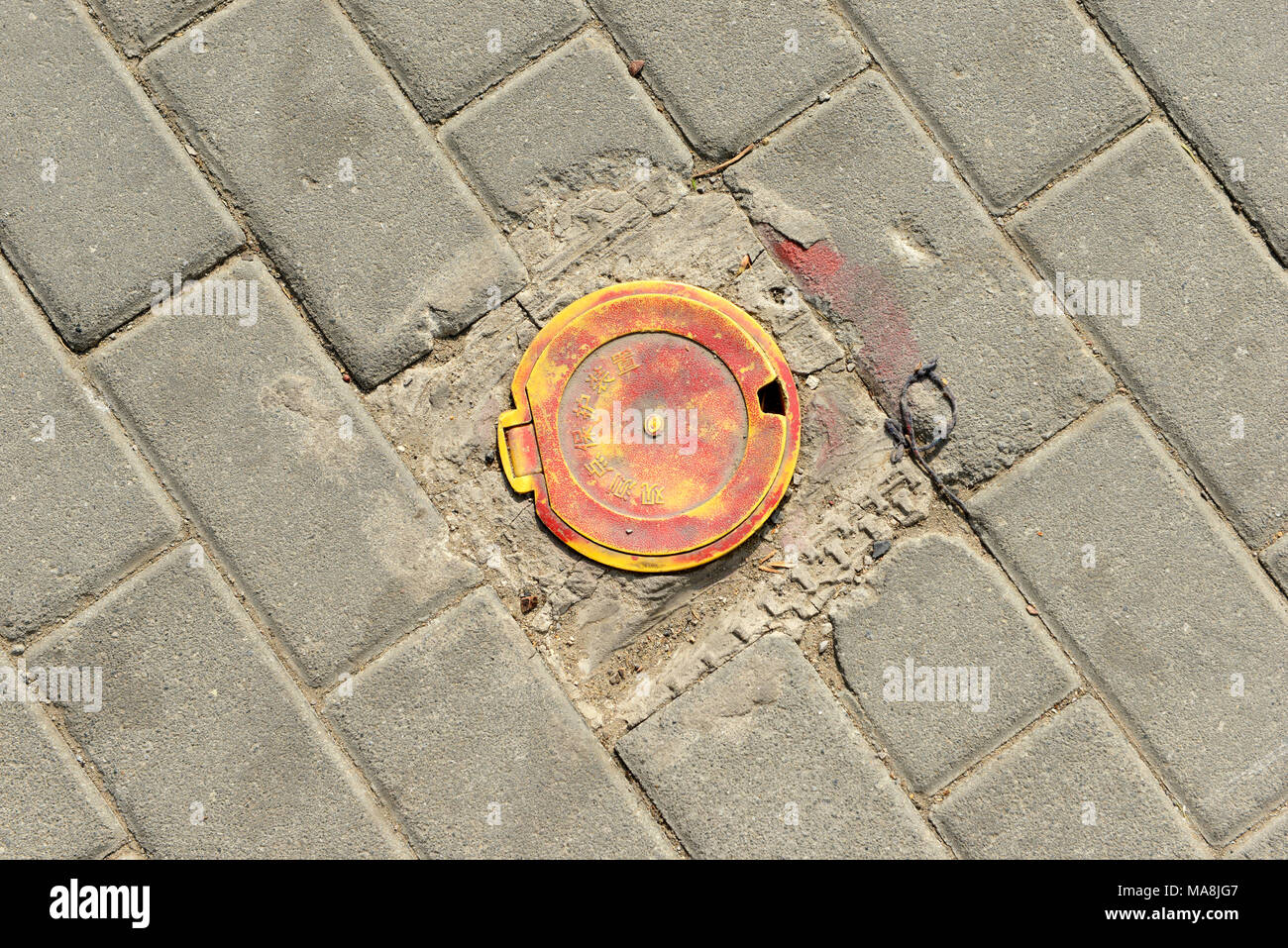 A utility access cover set in a pavement in Chaoyang District, Beijing ...
