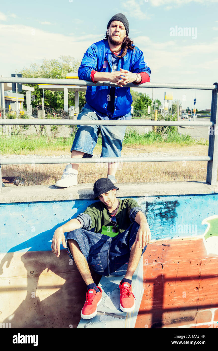 two rap singers in a subway with graffiti in the background posing in ...