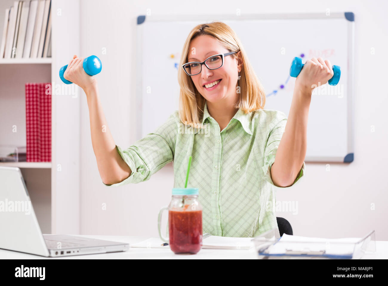 Happy businesswoman is getting ready for work in her office Stock Photo ...