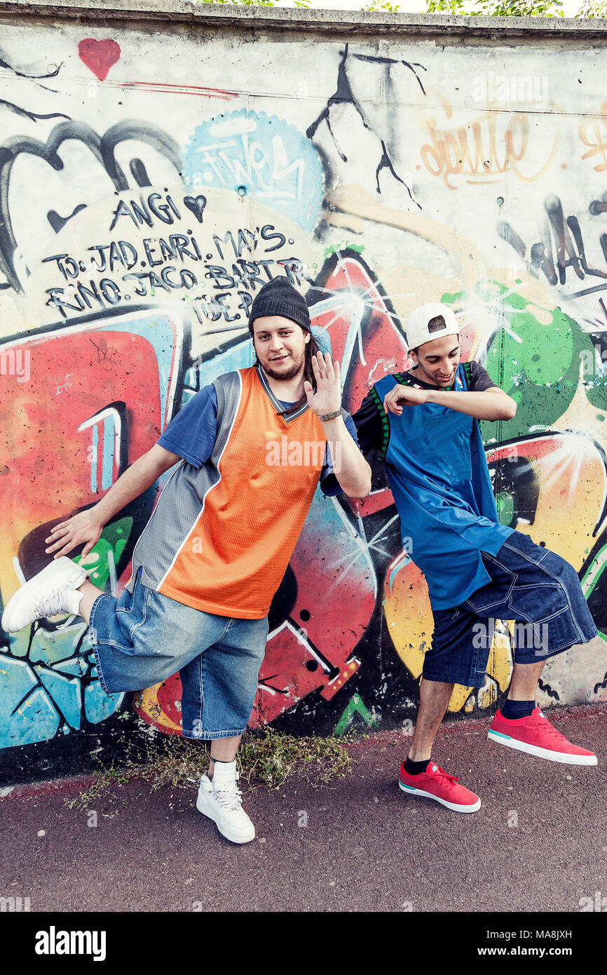 two rap singers in a subway with graffiti in the background posing in ...