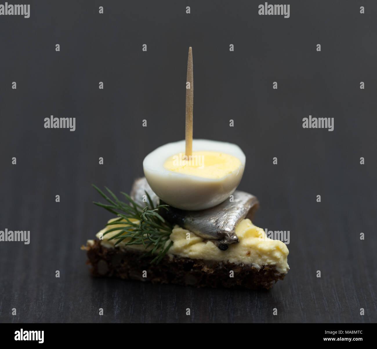 Mini sandwich with salt sprat and sliced boiled quail egg on the slice ...