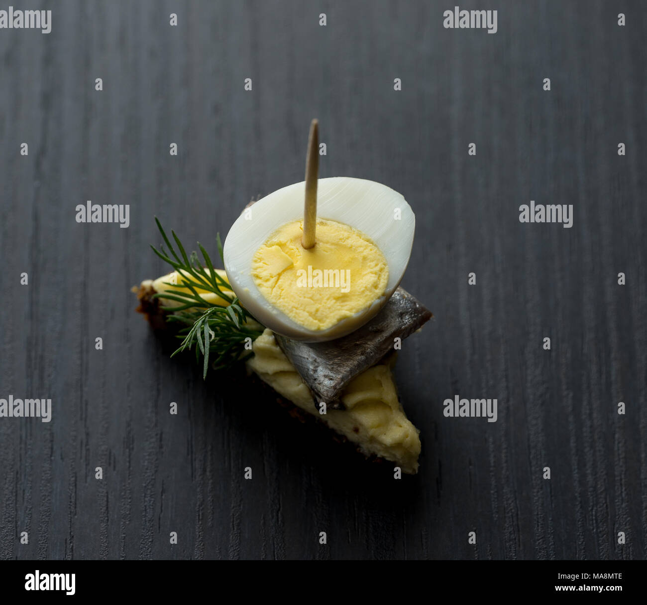 Mini sandwich with salt sprat and sliced boiled quail egg on the slice ...