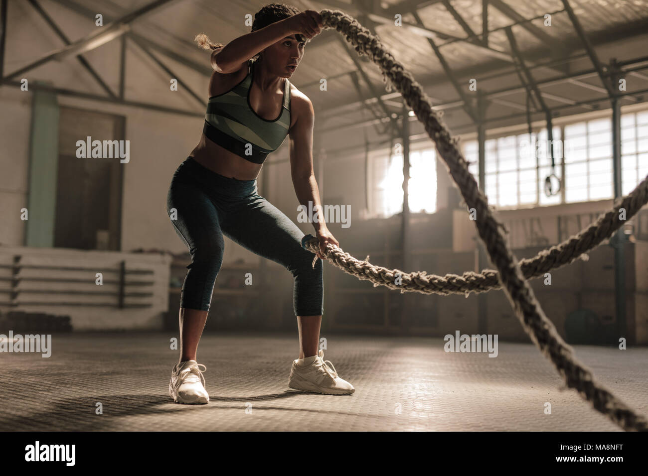 fitness woman using training ropes for exercise at gym. Athlete working ...