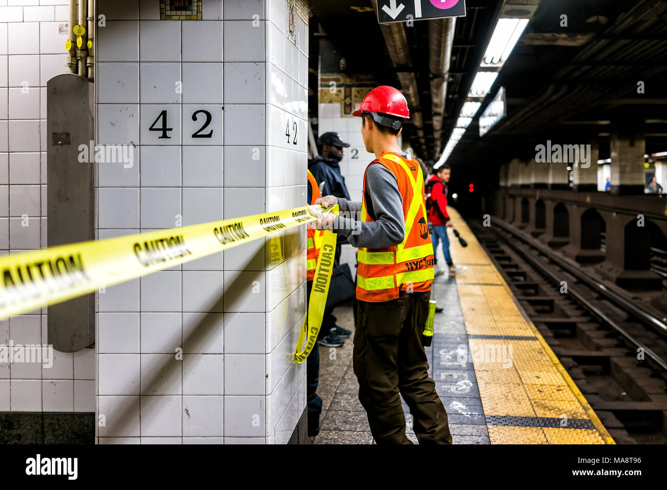 New York City, USA - October 29, 2017: Employee worker wrapping caution ...