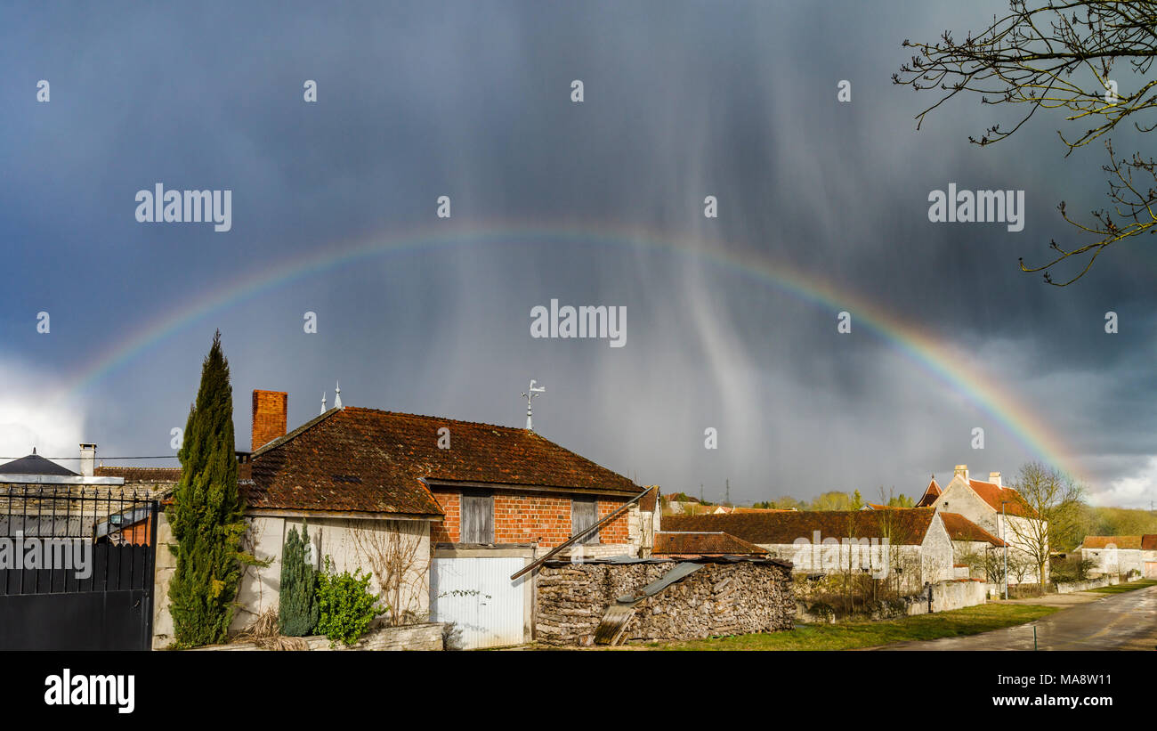 Full rainbow over the little city. Stormy spring weather. Bourgogne ...