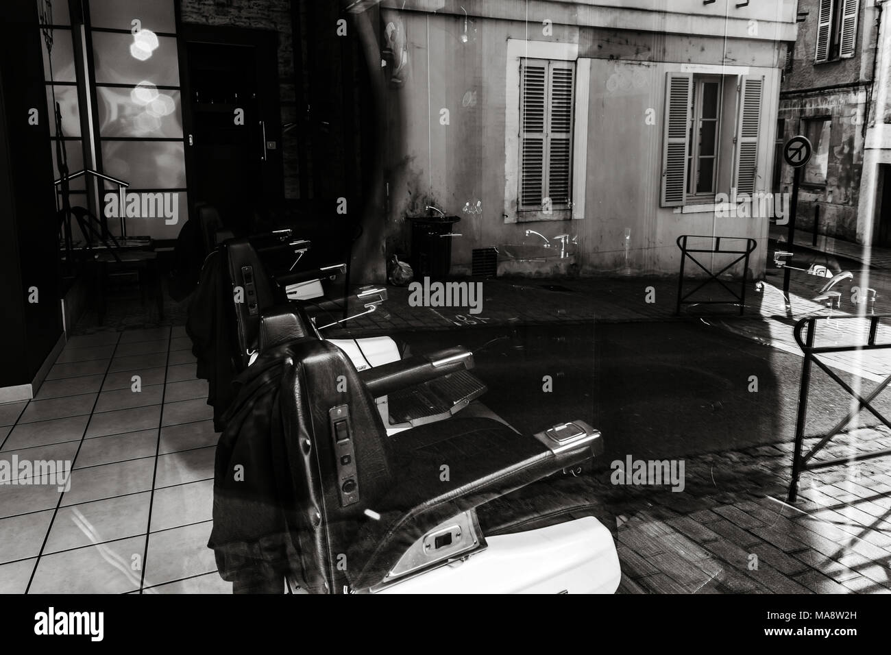 Old-styled barber shop view through the window with street reflecting ...