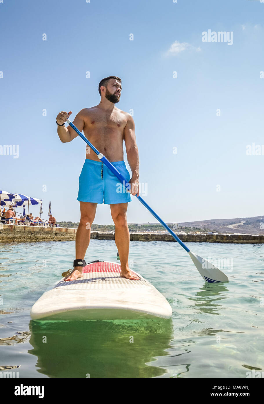 Man paddling on Sup board in blue sea. Beginner paddler Summer active ...