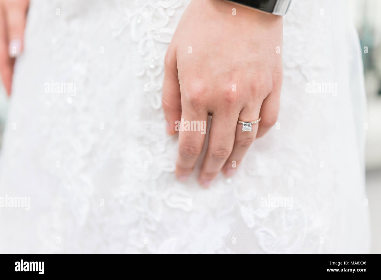 Closeup of princess cut diamond engagement ring on woman's female hand ...