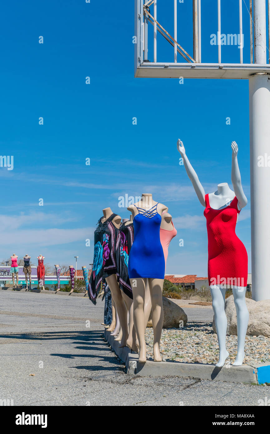 Multiple mannequins displayed outside in a strange surrounding along a ...