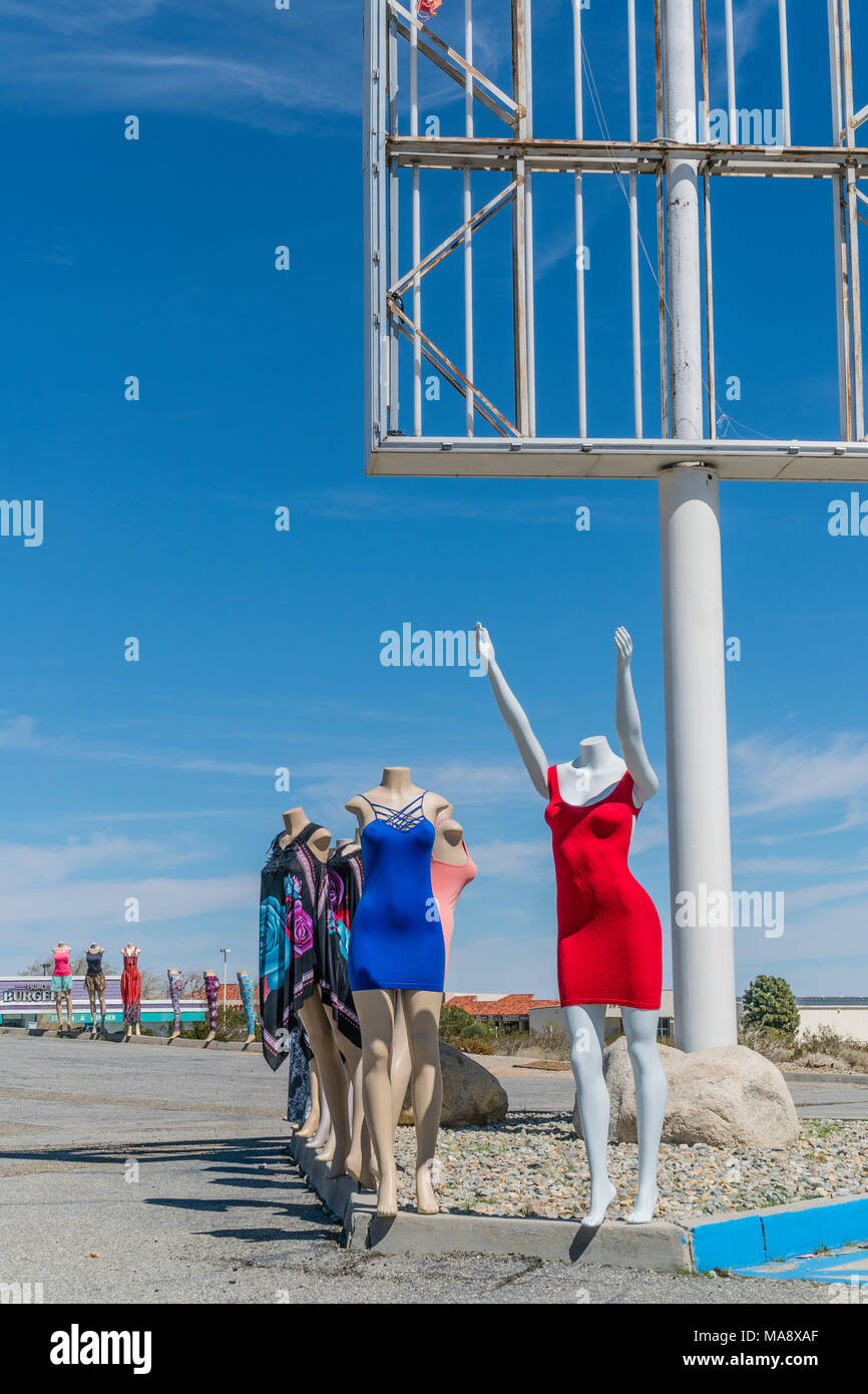 Multiple mannequins displayed outside in a strange surrounding along a ...