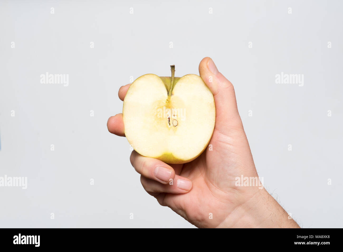 An apple cut in hand Stock Photo - Alamy