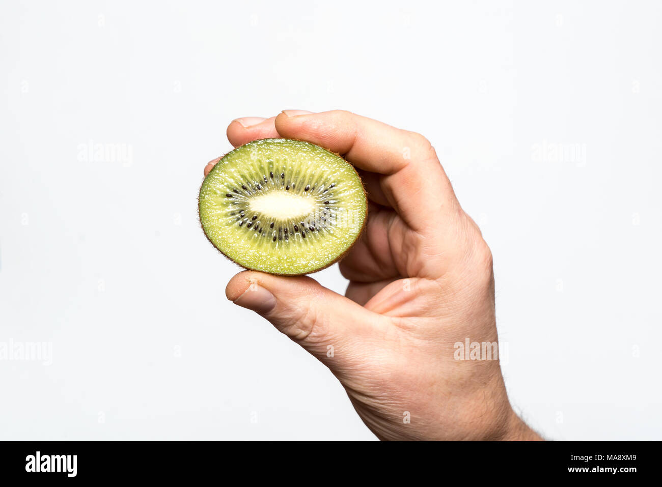 a kiwi cut in hand Stock Photo - Alamy